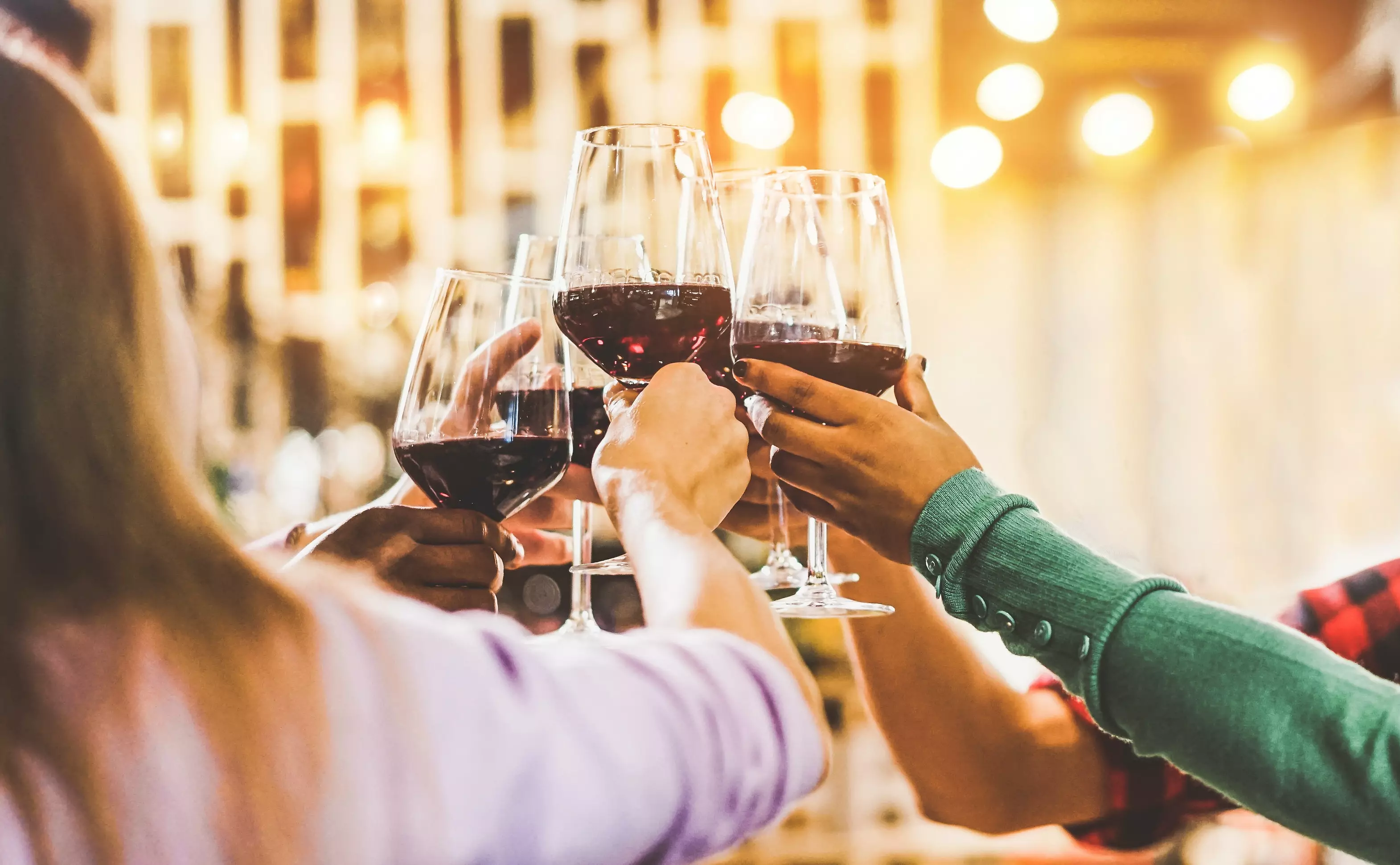 Un grupo de amigos anima con su vino tinto en un bar.