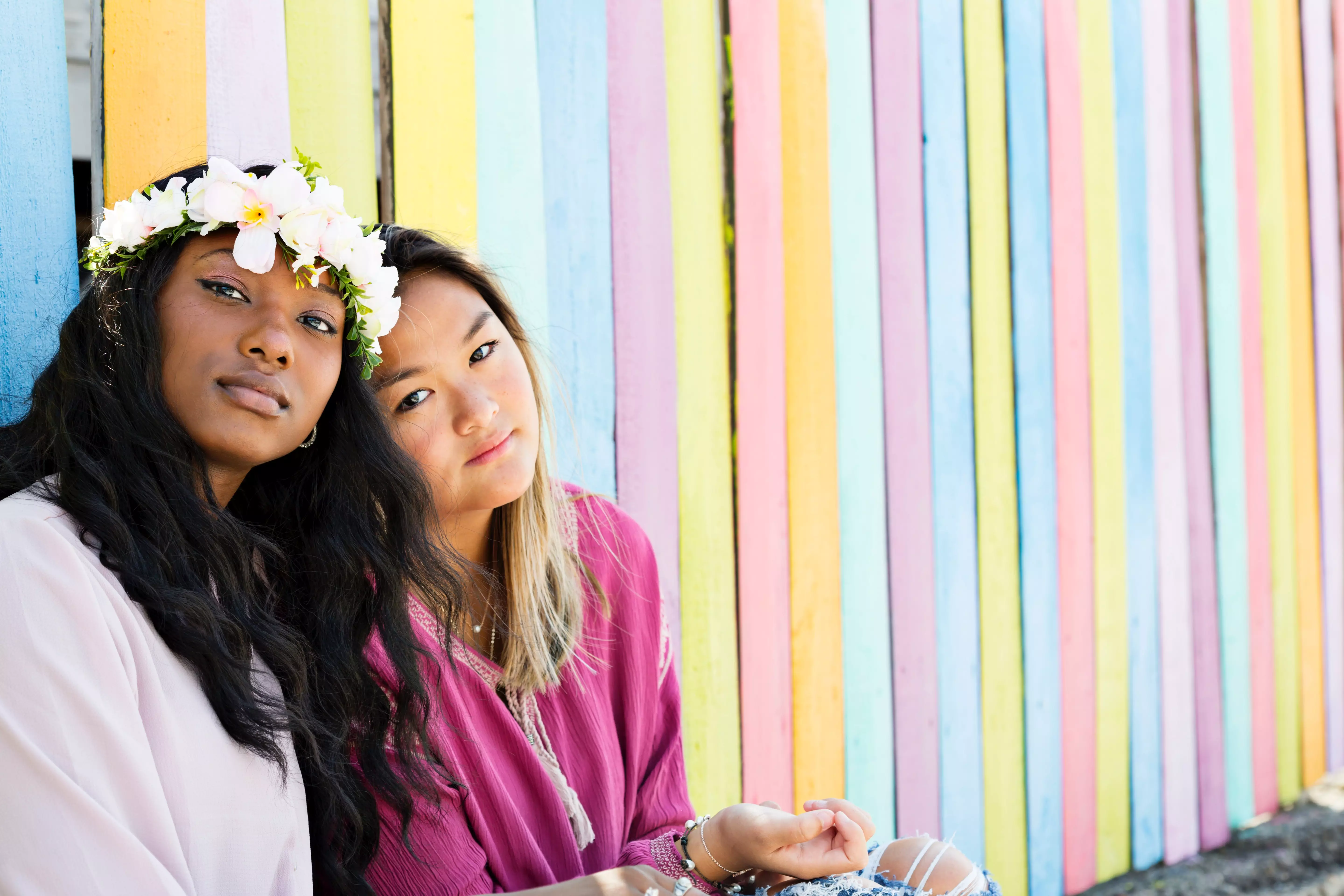 Des amis assis devant un mur pastel auraient besoin de légendes et de citations d'avril pour Instagram.