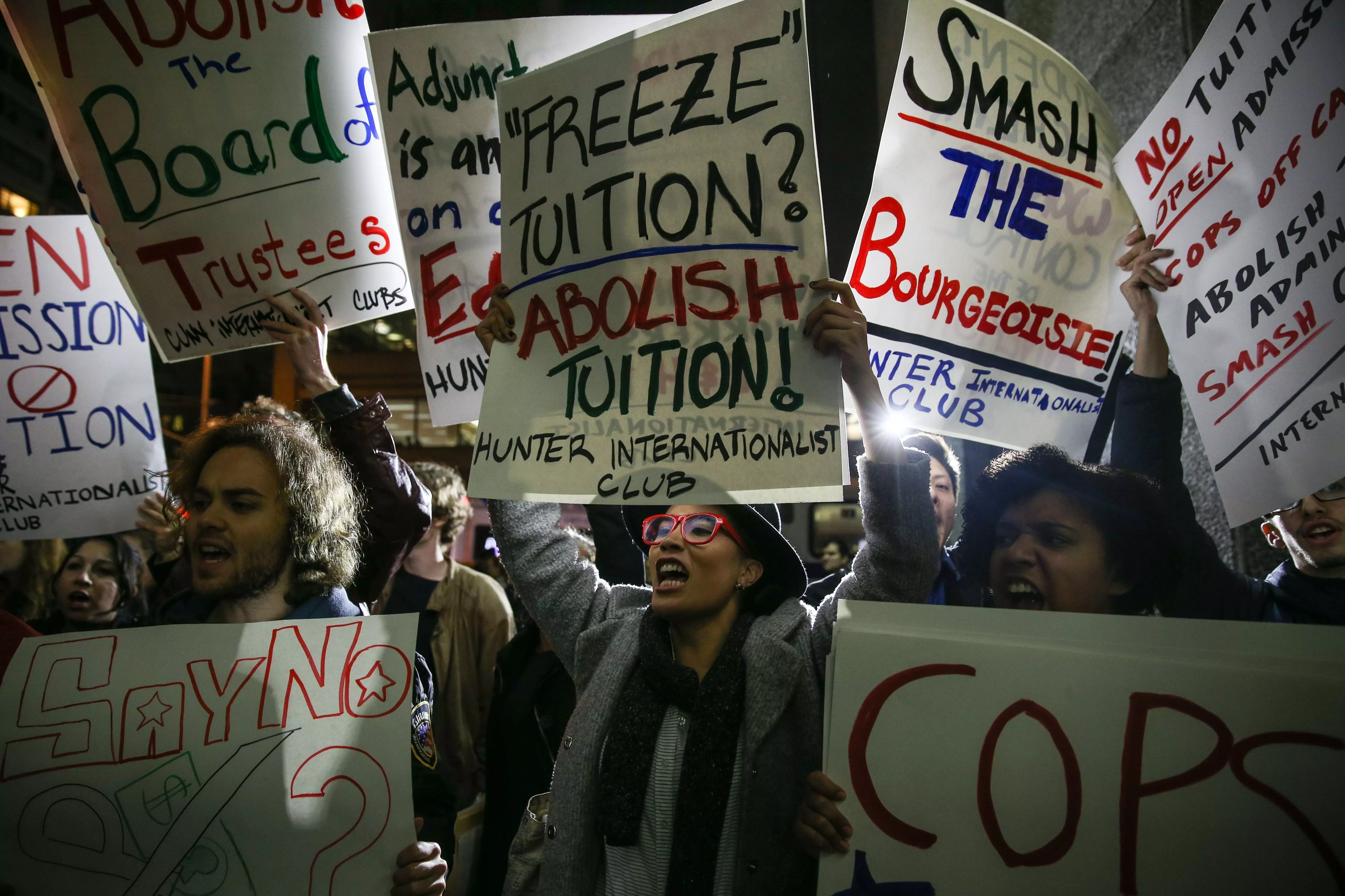 Studenten houden borden vast tijdens een demonstratie tegen studieschuld op Hunter College in New York...