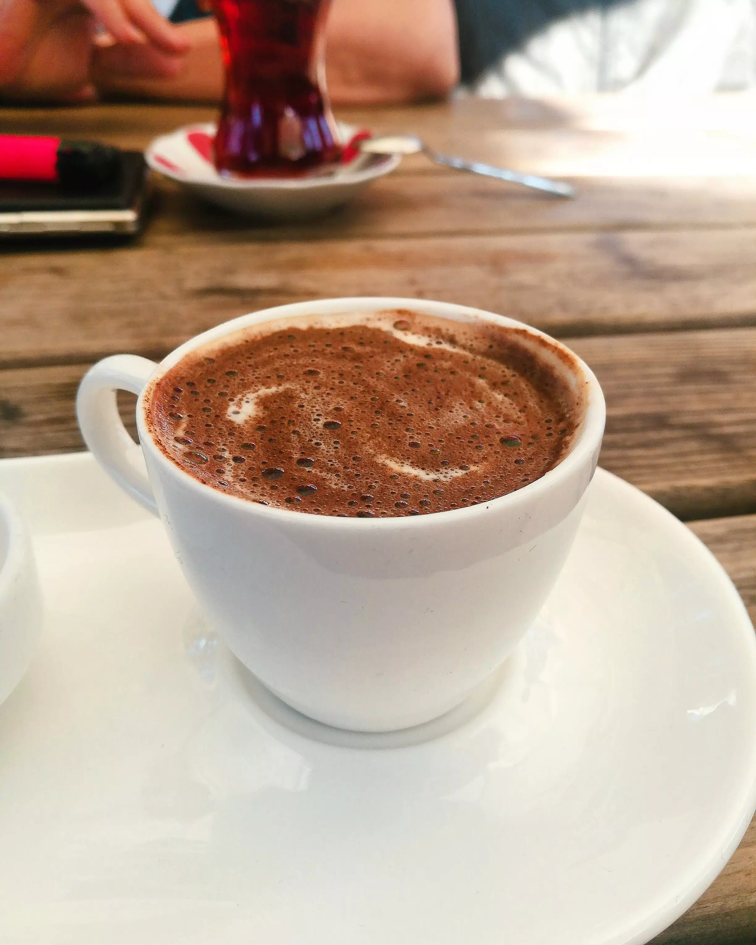 Een kop warme chocolademelk staat op een houten tafel.